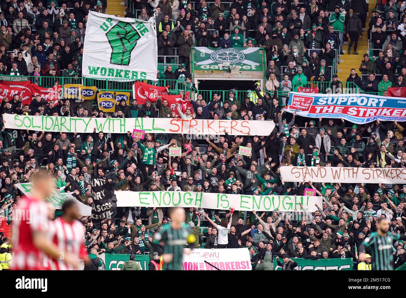 Celtic fans in the stands hold up banners showing solidarity with all ...