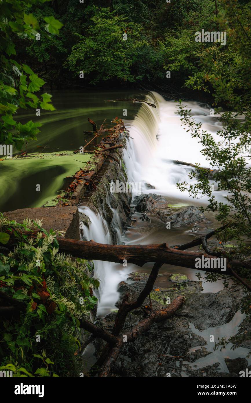 A vertical long exposure shot of a cascade waterfall in the middle of a ...