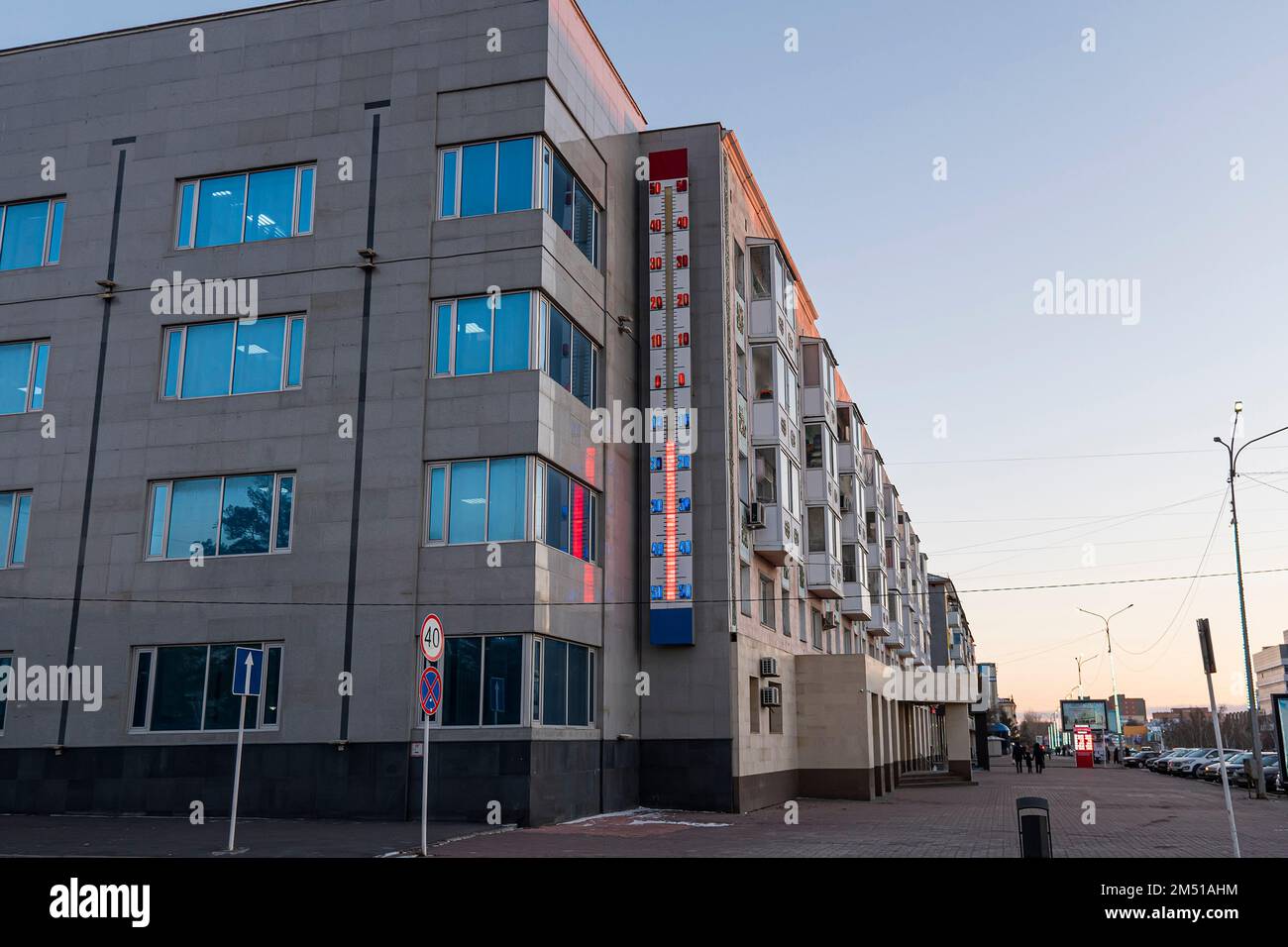 a thermometer on the street on the wall of the house shows a ...