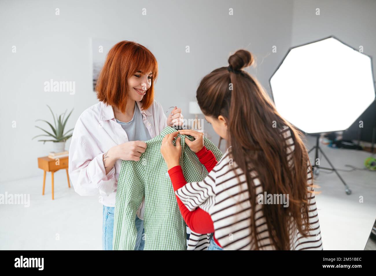 Happy beautiful young woman choosing clothes with girlfriend Stock ...