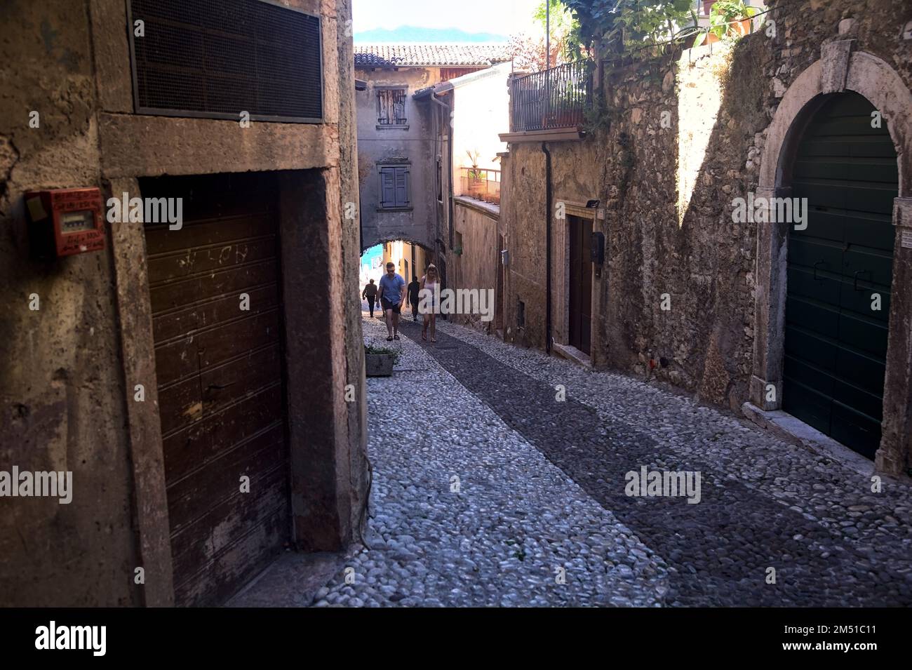 Narrow cobbled street that leads to a covered passageway in an old ...