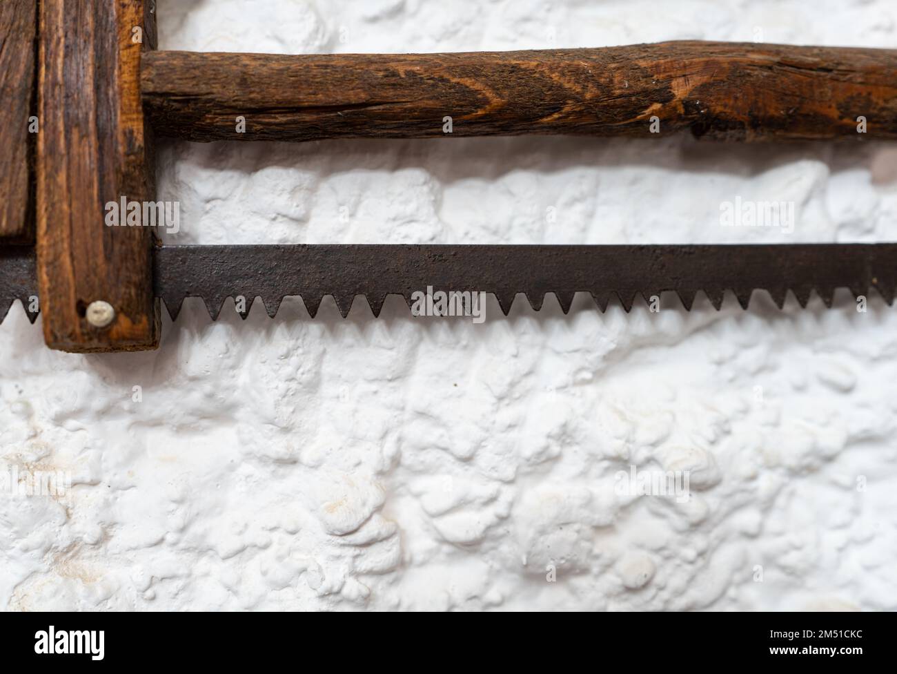 Old antique saw with wooden handle on the white wall Stock Photo - Alamy