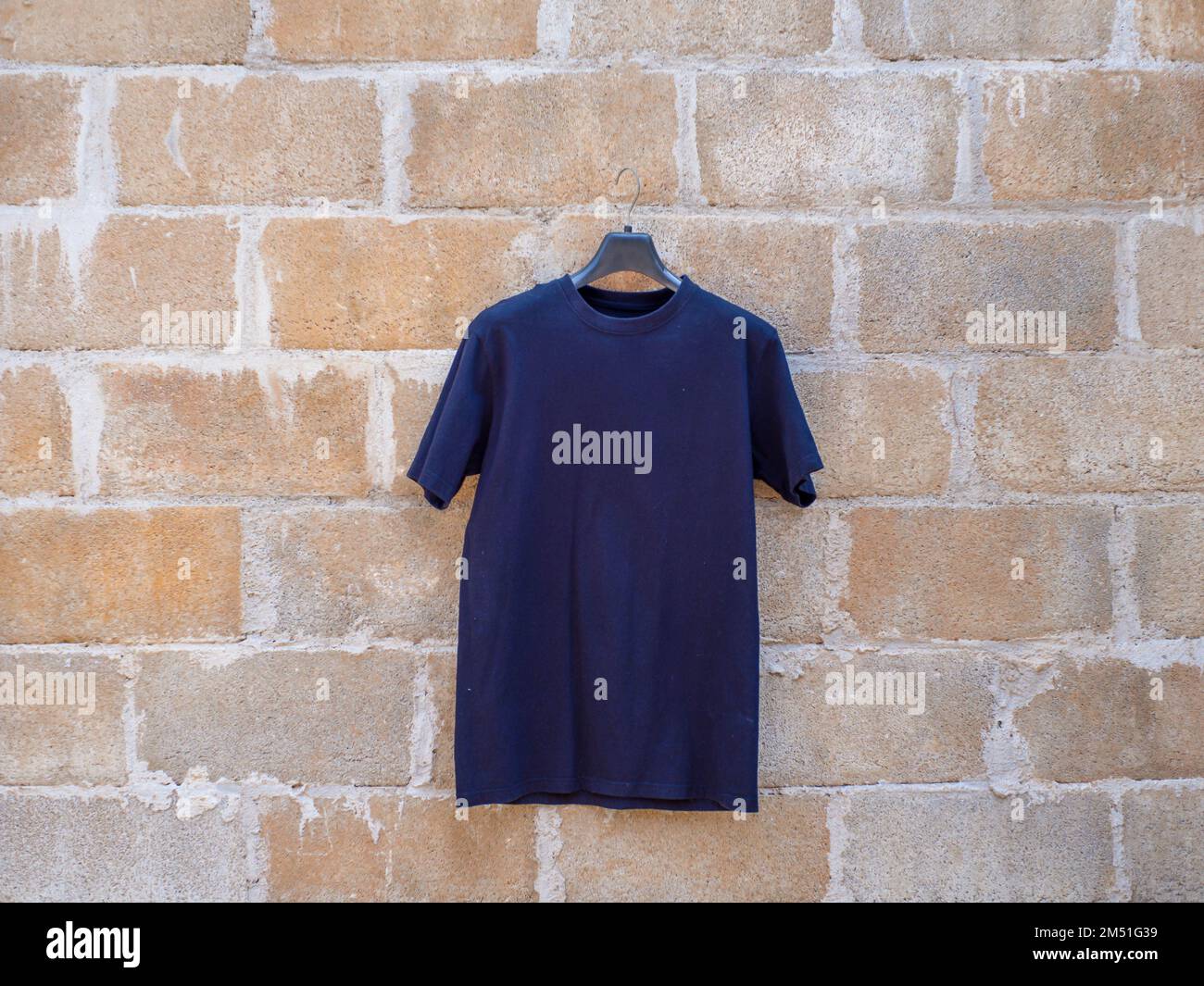 Dark Blue t-shirt with brick background Stock Photo - Alamy