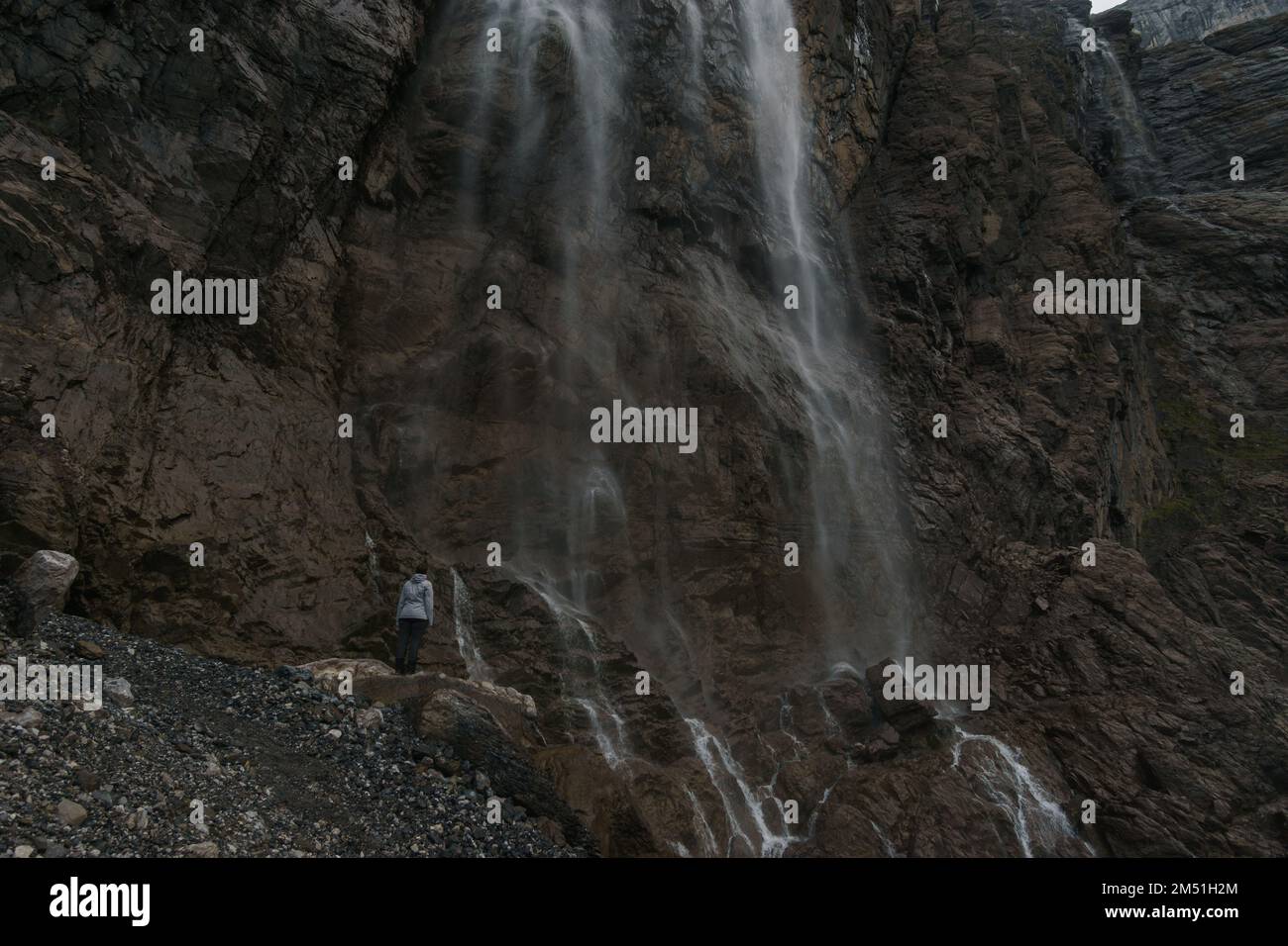 Cirque de Gavarnie with big waterfall and small person at massive high ...