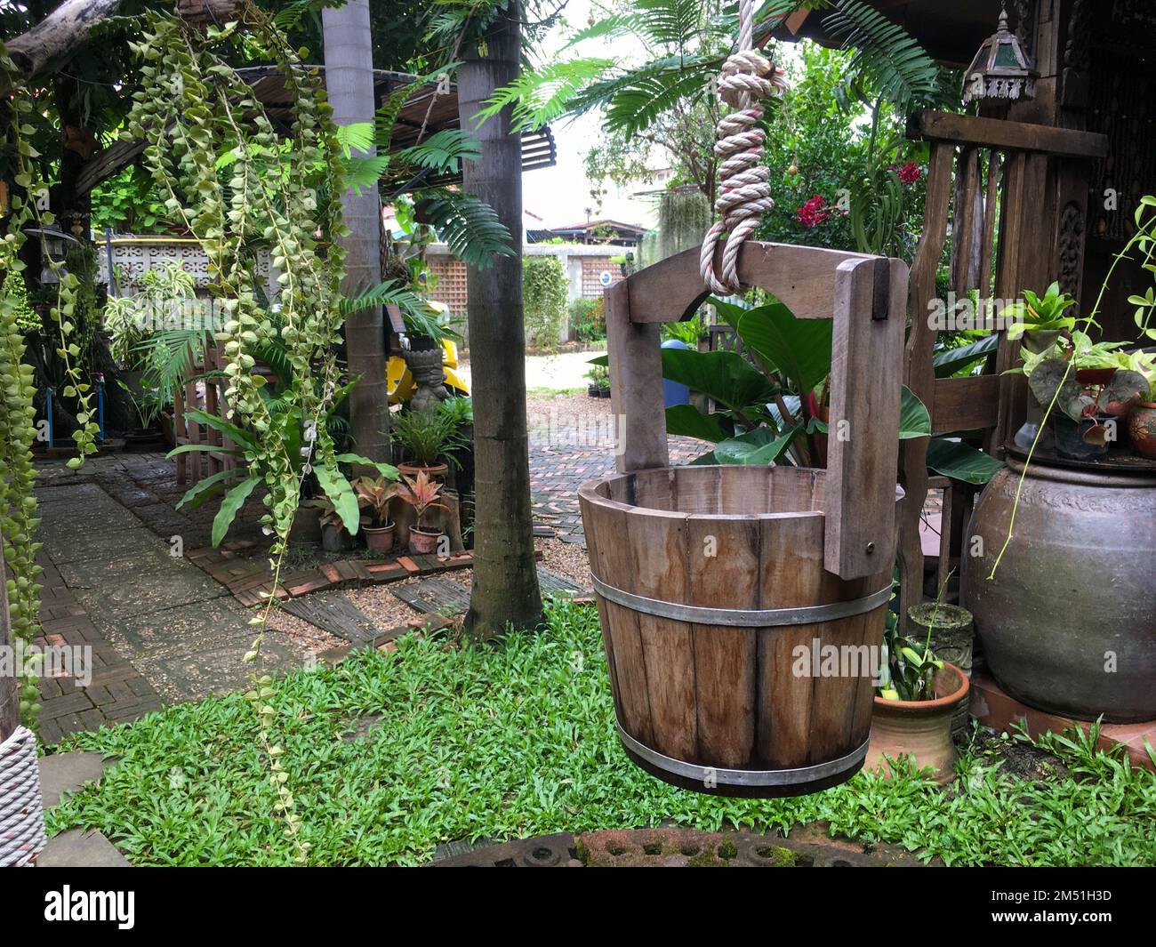 An old wooden bucket with a rope tied to a wooden beam Stock Photo - Alamy
