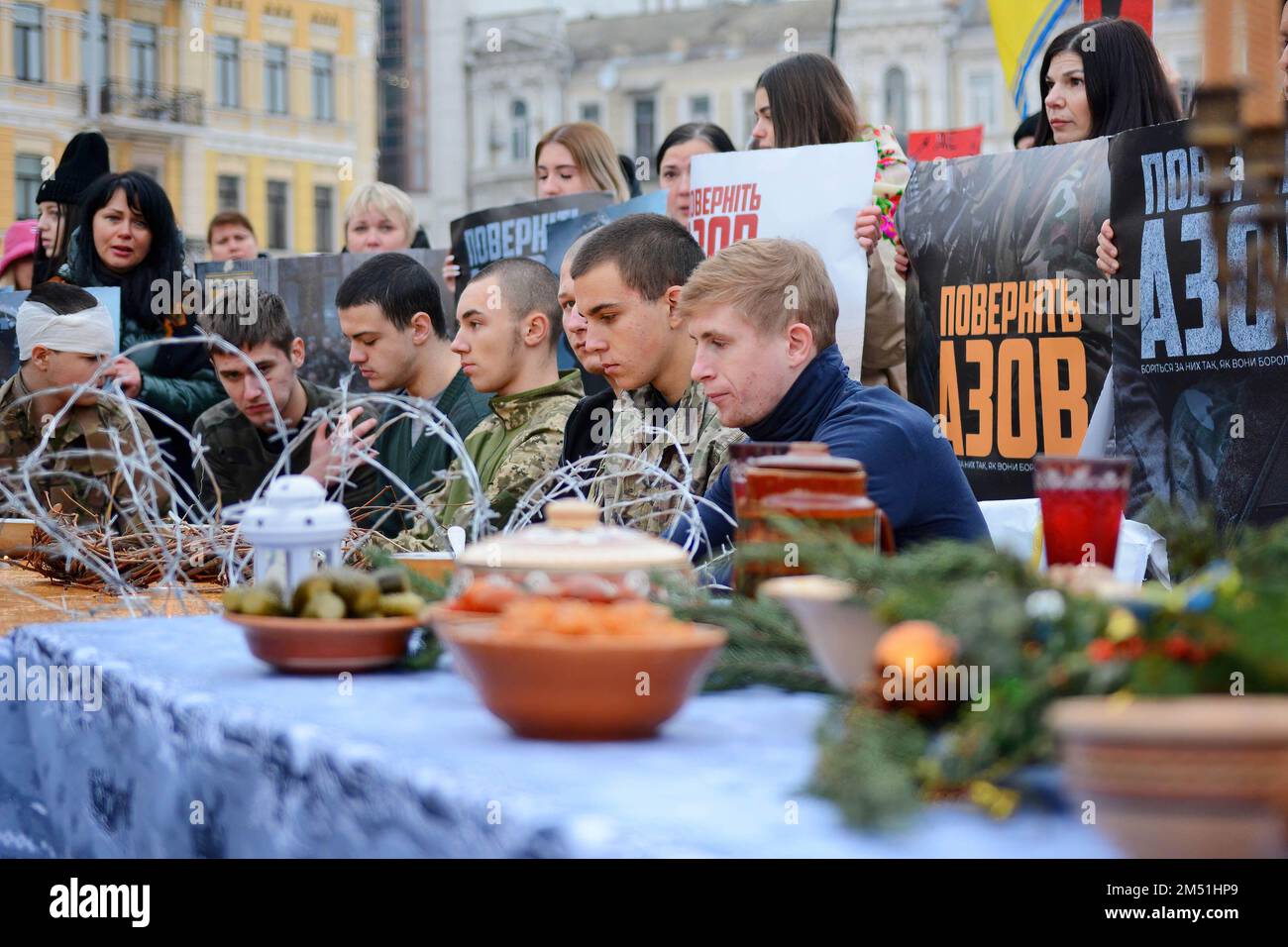 Men sit at the table symbolizing the prisoners during the peaceful ...