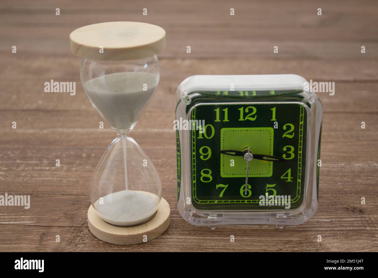 Image of a clock with hands and an hourglass. Difference between the ...