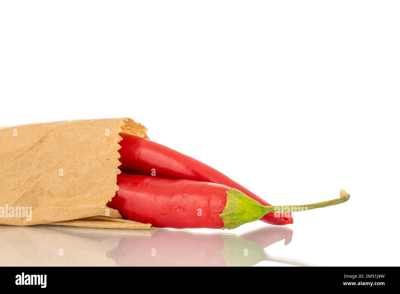 Two red hot peppers in a paper bag, macro, isolated on white background ...
