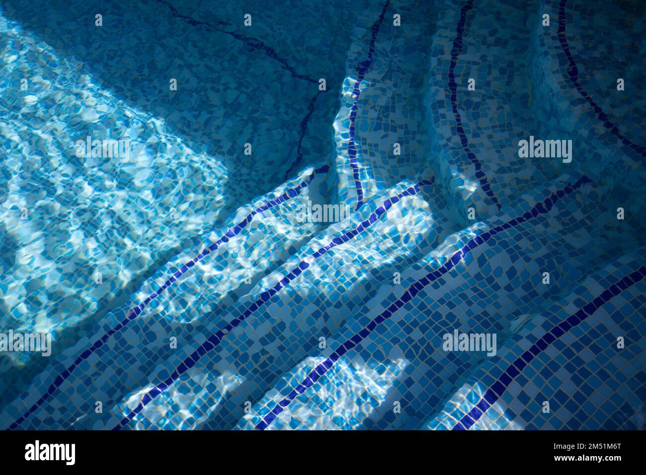 Stairs of the swimming pool in sunlight under water. Design of the ...