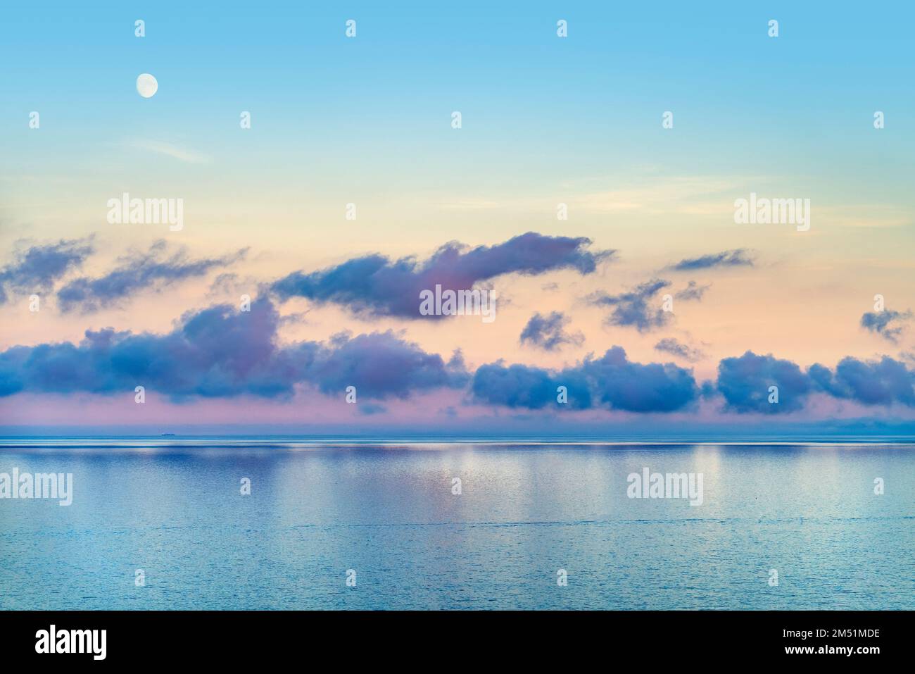 Ocean scenery including some clouds and a distant container ship at ...