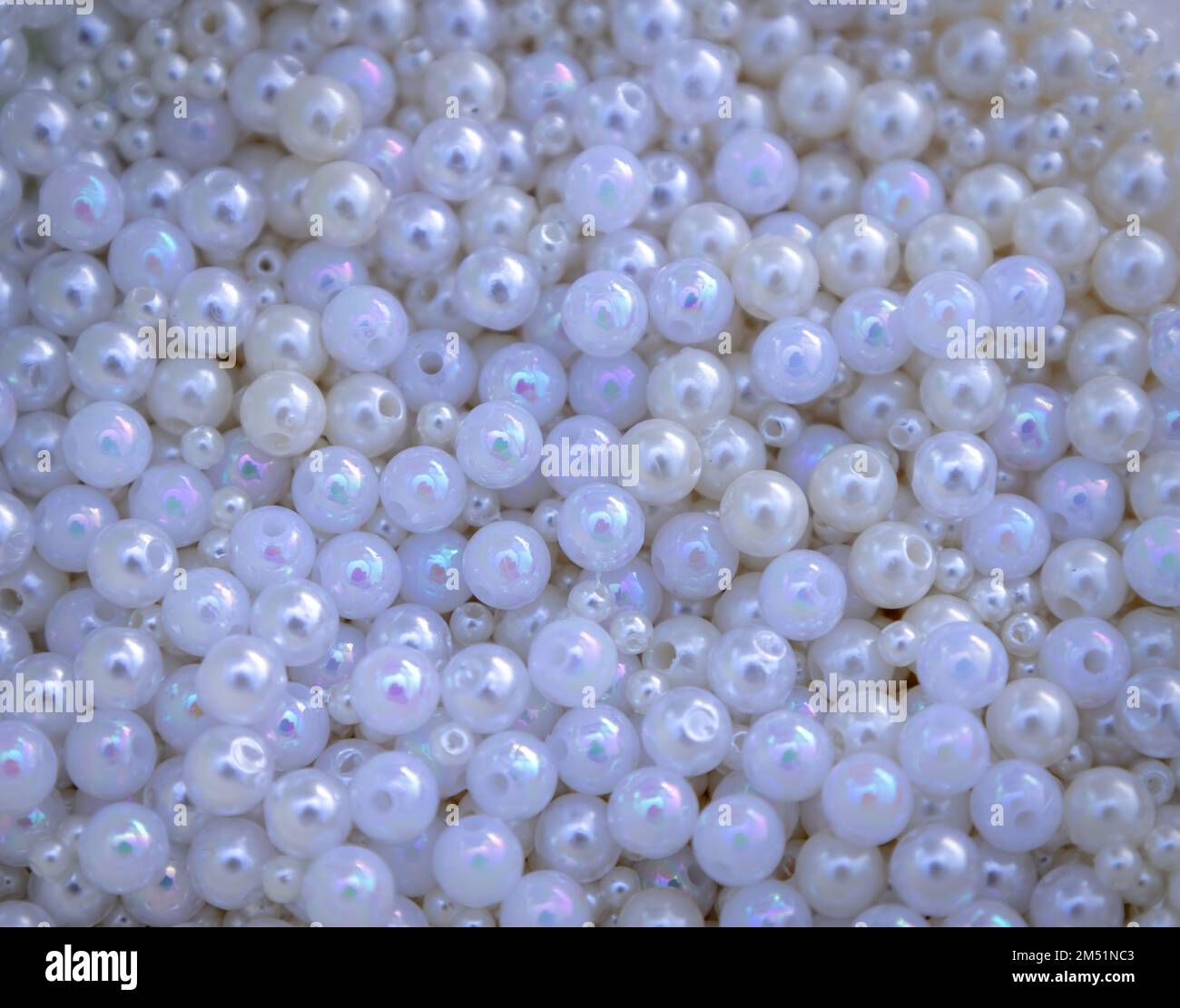 Several pearlescent and white pearls with holes to form necklaces ...