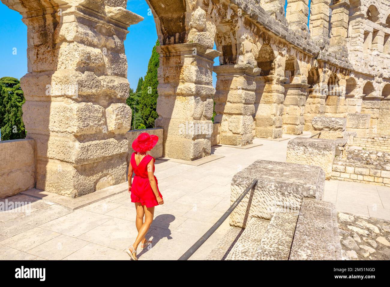 Tourist girl walking inside Pula Amphitheater or Coliseum of Pula is a ...