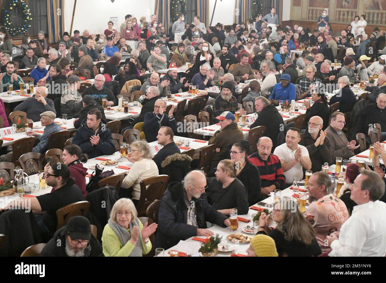 Munich, Germany. 24th Dec, 2022. Homeless people wait for food in the ...