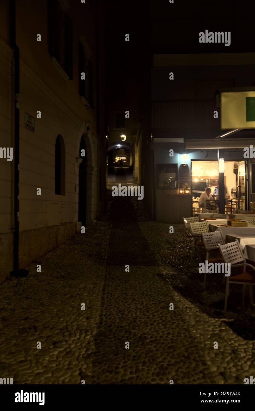 Square with restaurant and people dining at night Stock Photo - Alamy