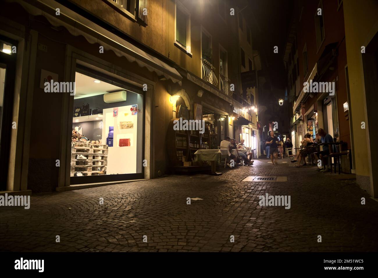 Square with restaurant and people dining at night Stock Photo - Alamy
