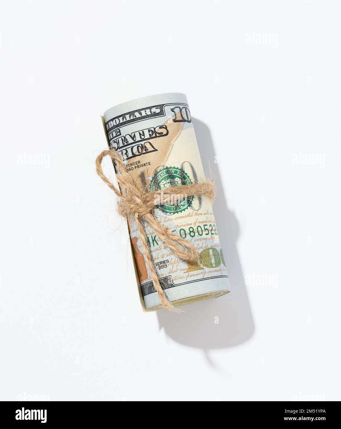 Rope tied roll of one hundred dollar bills isolated on white background ...