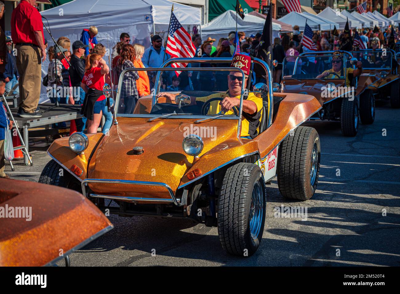 The Shriners in gold dune buggy in small town during Applefest parade ...