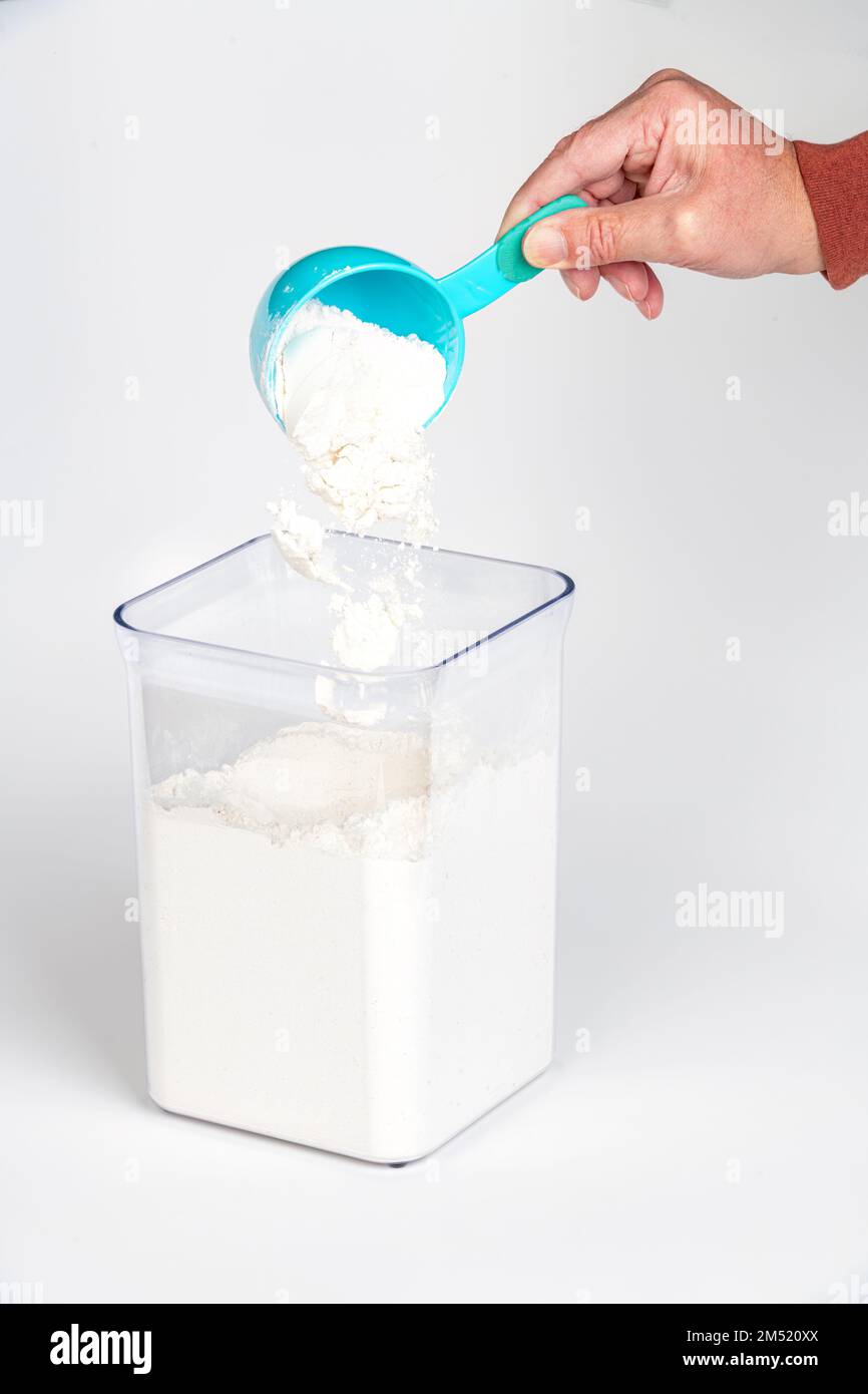 Cook scoops some flour from a storage container Stock Photo - Alamy