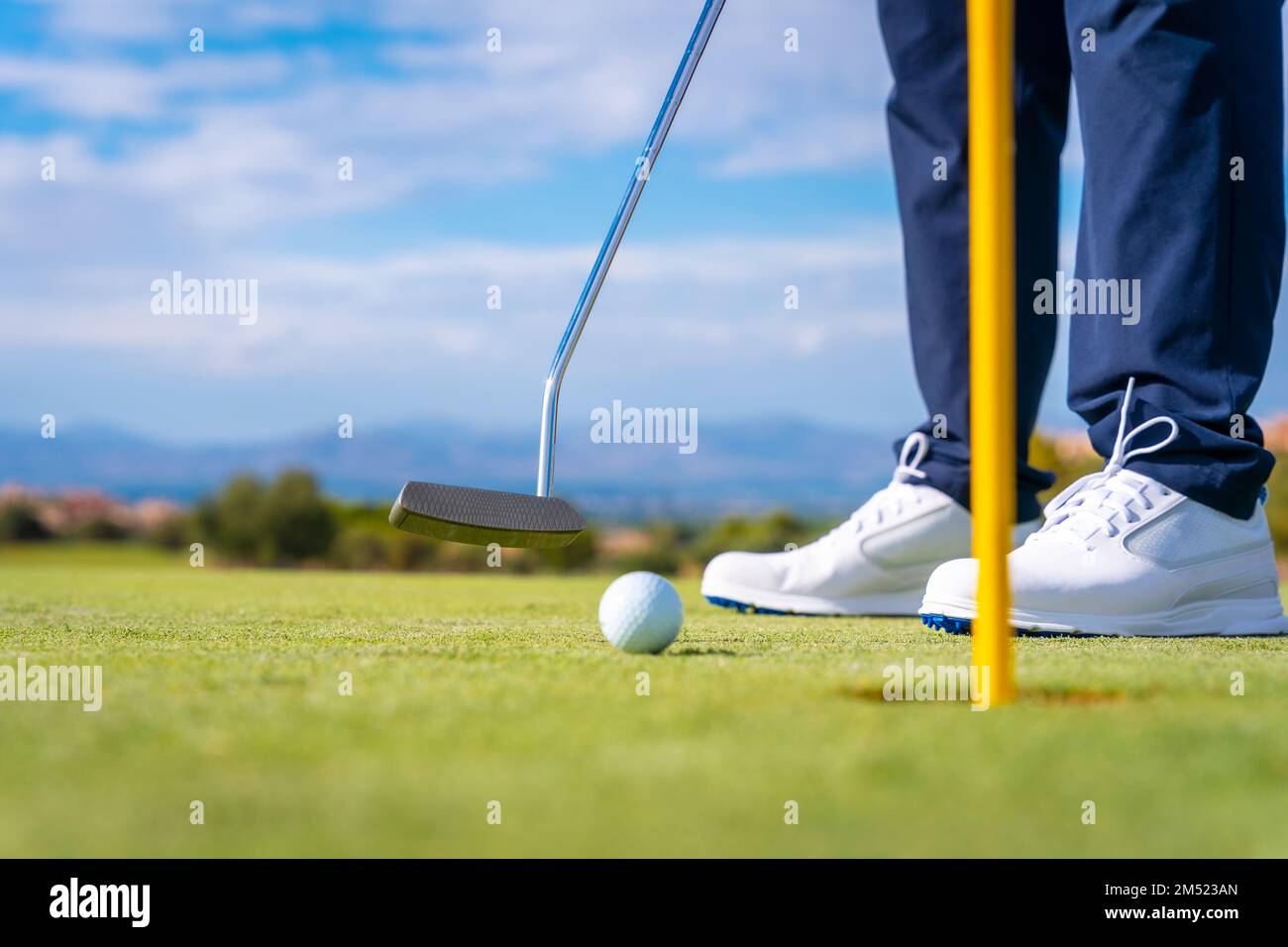 A professional male golf player playing golf at golf club by a lake ...