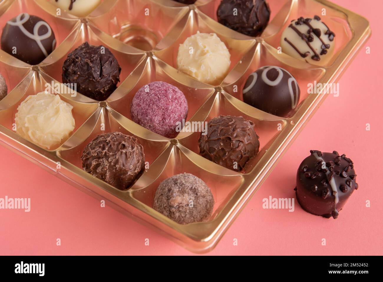 photo round chocolates lying in a box on a pink background Stock Photo ...