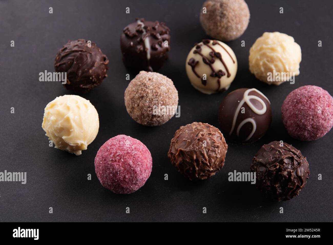 photo multicolored round chocolate candies on a black background Stock ...