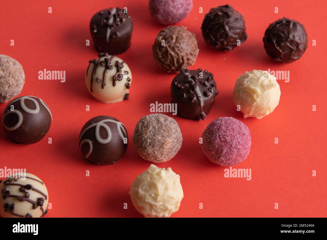 photo different candies with chocolate filling on a red background ...