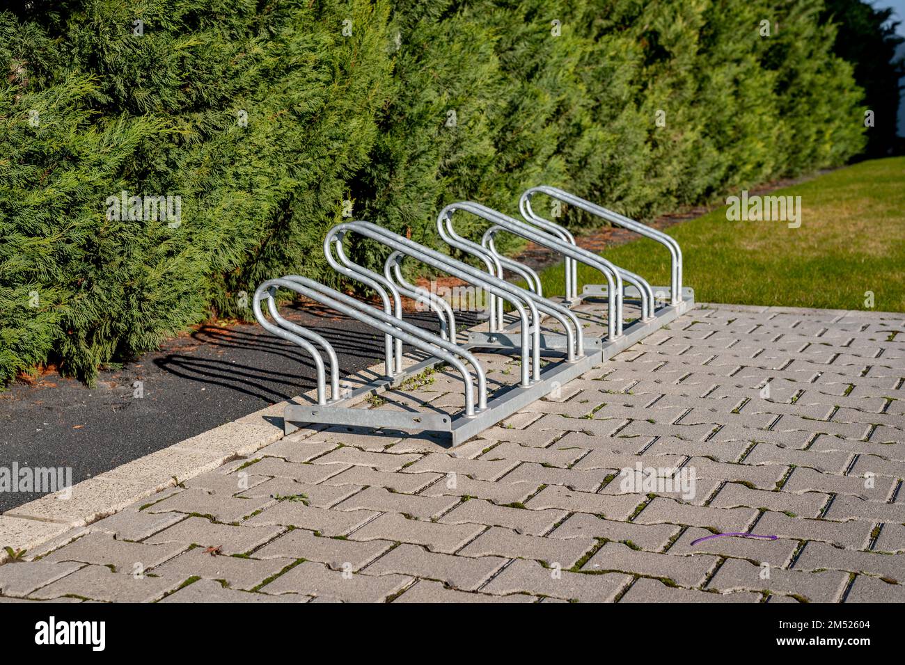 Image of empty bicycle parking rack in front of a row of hedges Stock ...