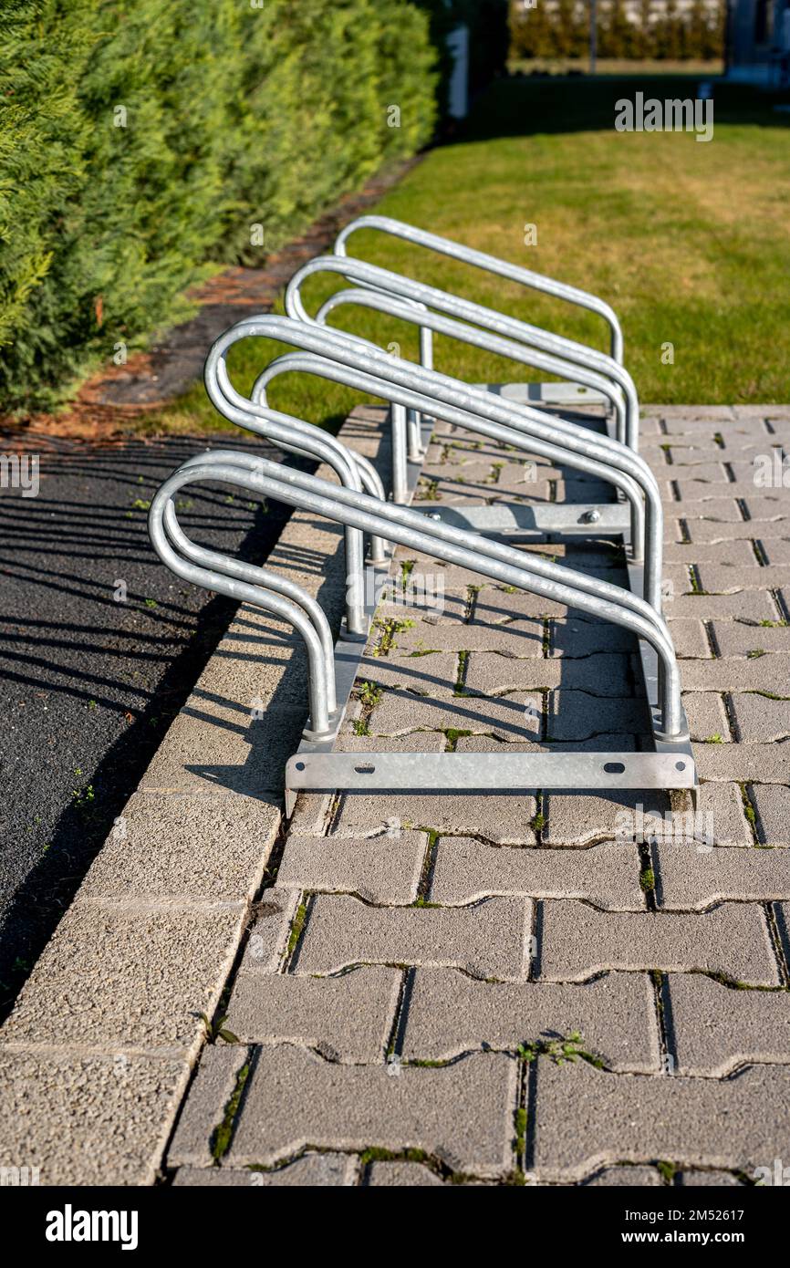 Image of empty bicycle parking rack in front of a row of hedges Stock ...