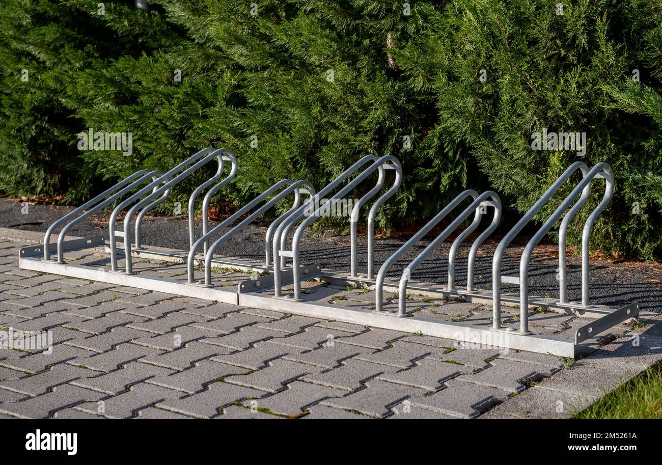Image of empty bicycle parking rack in front of a row of hedges Stock ...