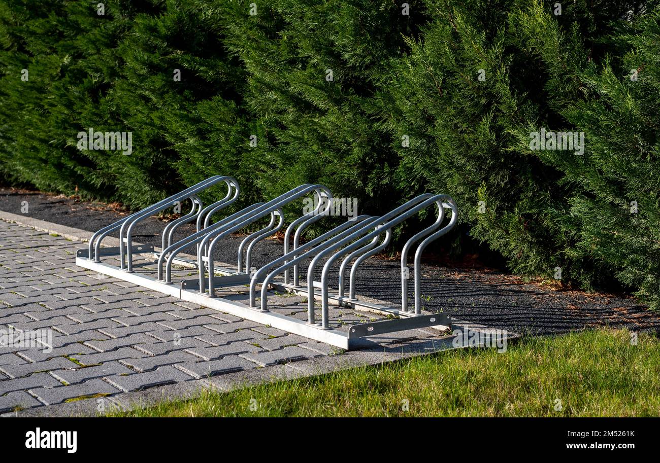 Image of empty bicycle parking rack in front of a row of hedges Stock ...