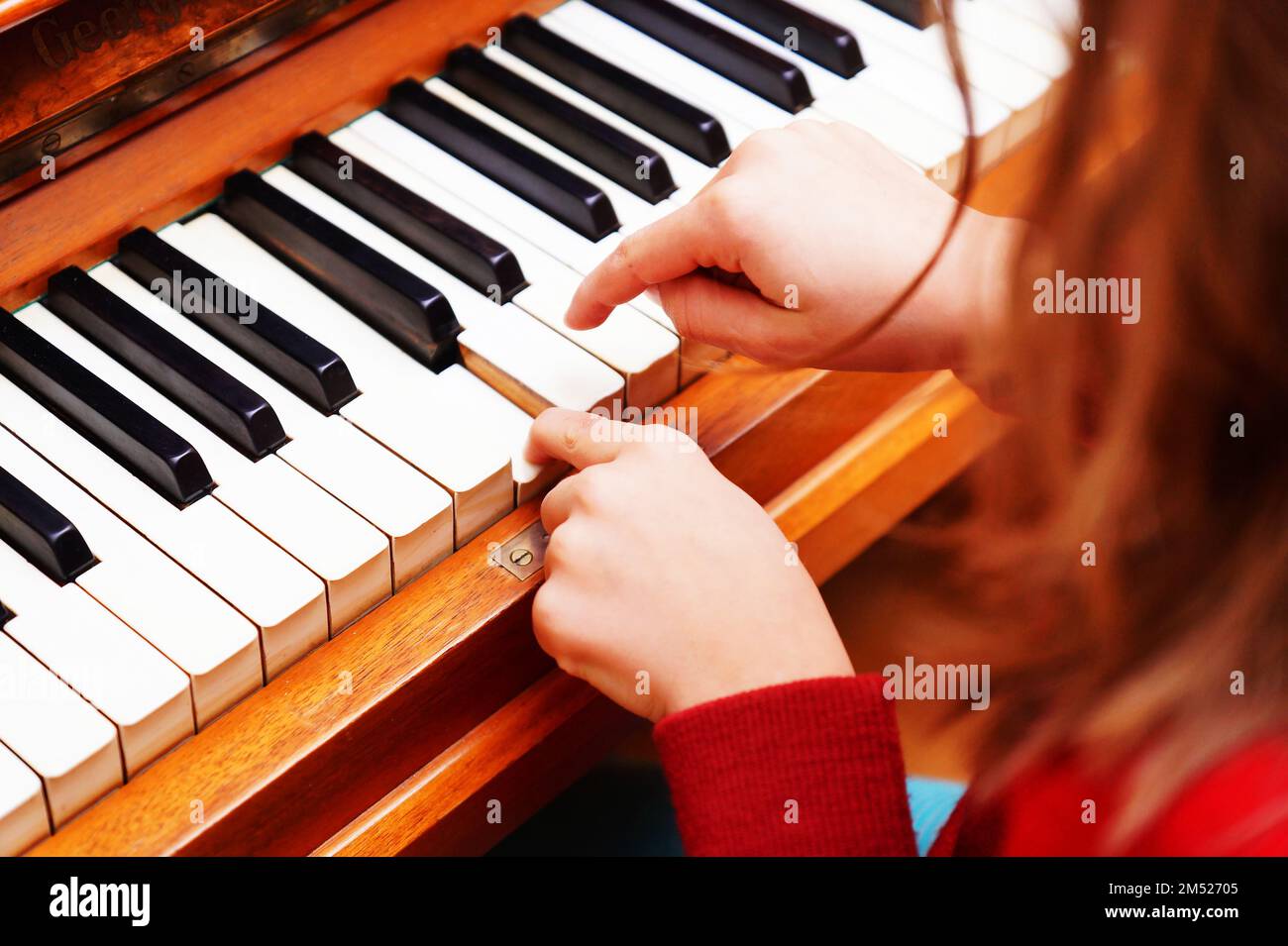 Child's hand timidly presses the piano keys Stock Photo - Alamy