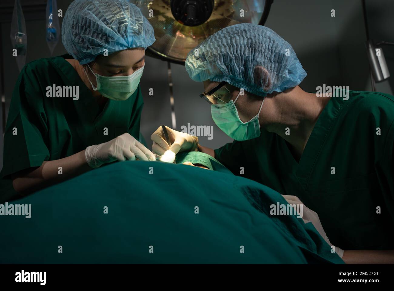 Asian Professional surgeons team performing surgery in the operating ...