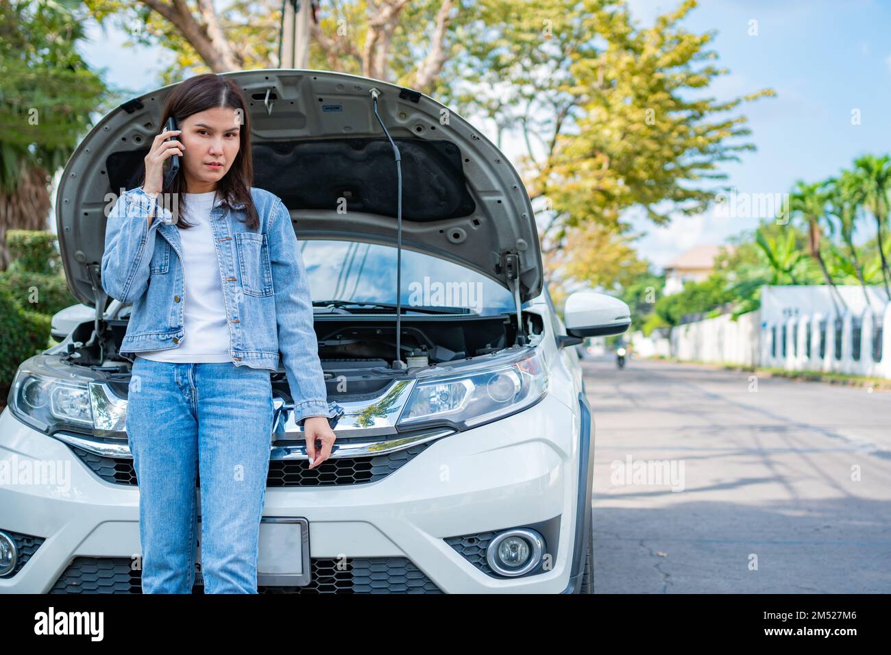 Angry Asian woman and using mobile phone calling for assistance after a ...