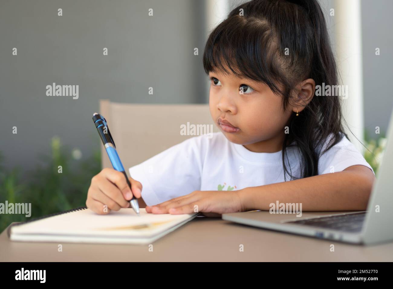 Asian girl student holding a pen for taking notes and doing homework ...