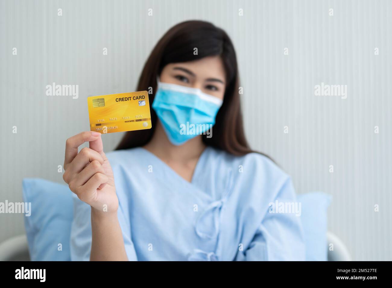Happy Asian woman wearing a medical mask and holding mock up credit ...