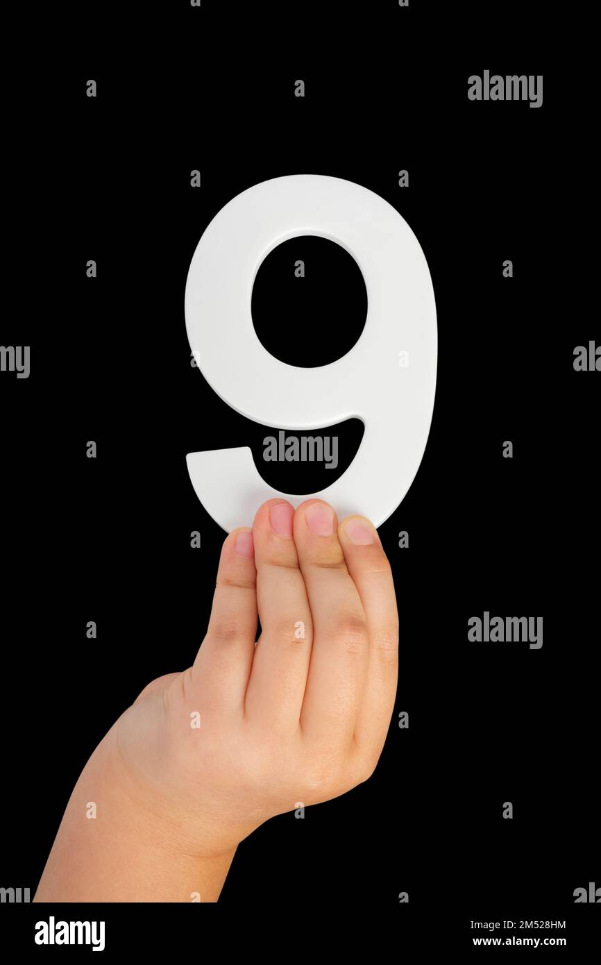 Number nine in hand isolated on black background. Number 9 in a child's ...