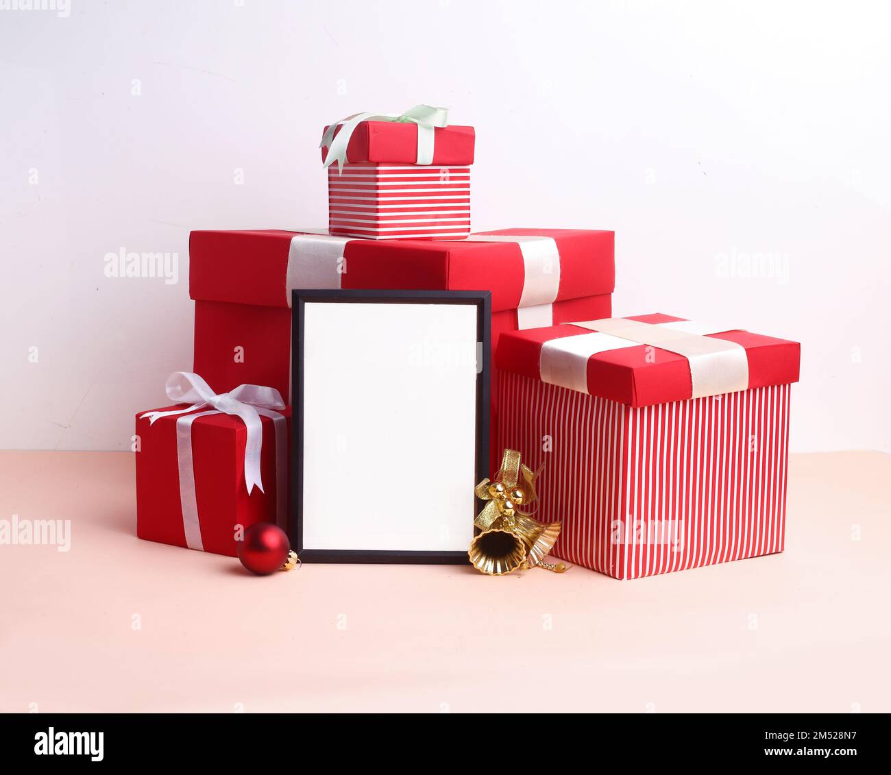 Cute Christmas setup with red gift boxes and blank wooden frame in the ...