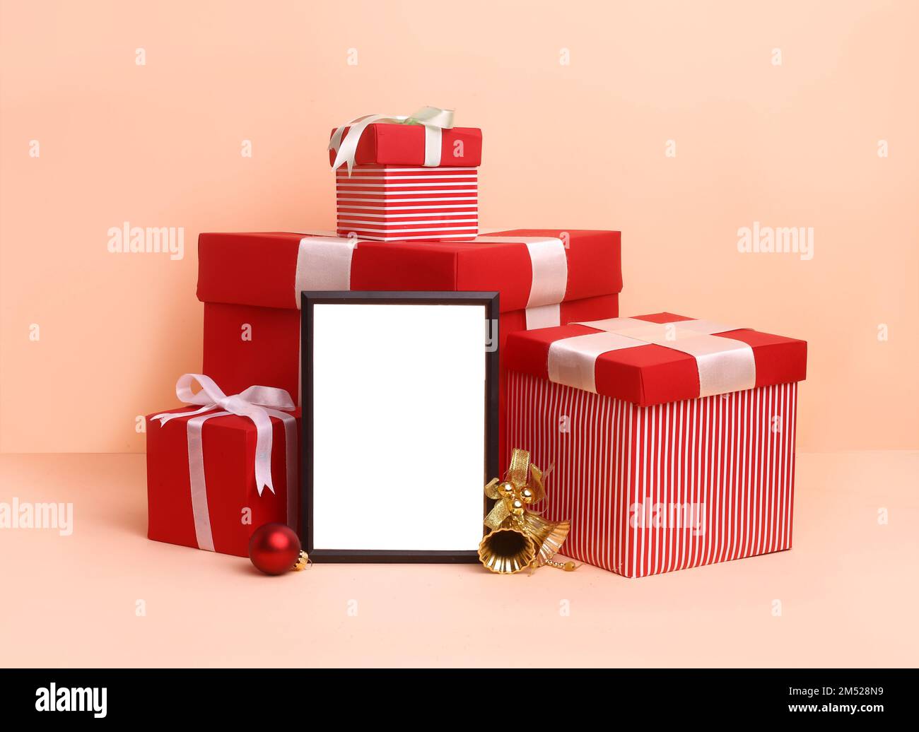 Cute Christmas setup with red gift boxes and blank wooden frame in the ...