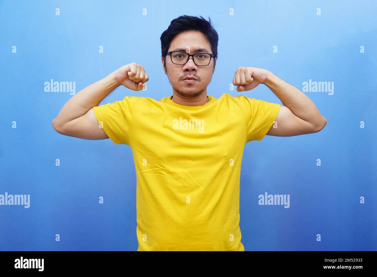 Excited Asian man showing strong gesture by raising his arms and ...