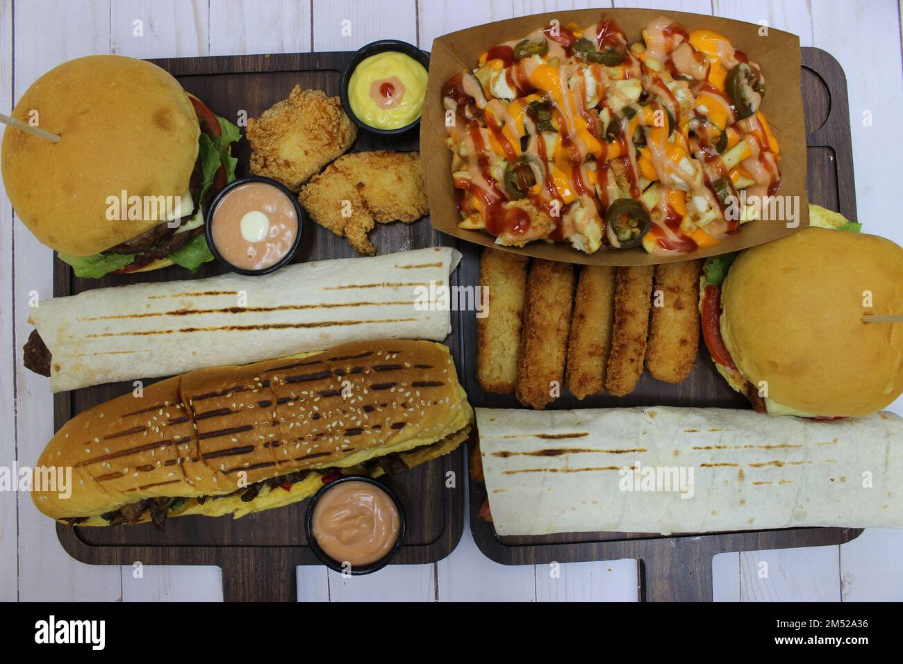 A top view of burger, chicken fries packet, cheese rolls and other ...