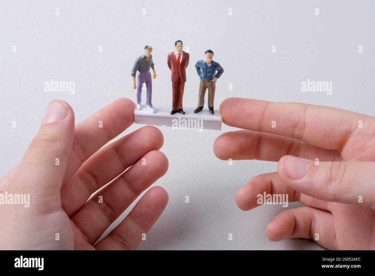 Tiny figurines of men miniature model in hand Stock Photo - Alamy