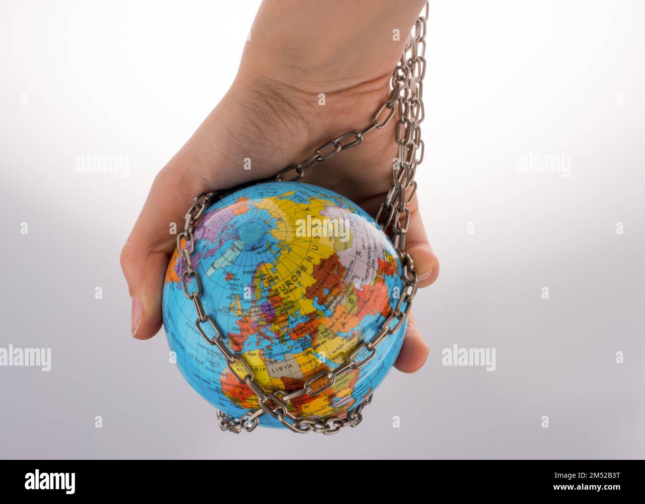 Globe in chain on a white background Stock Photo - Alamy