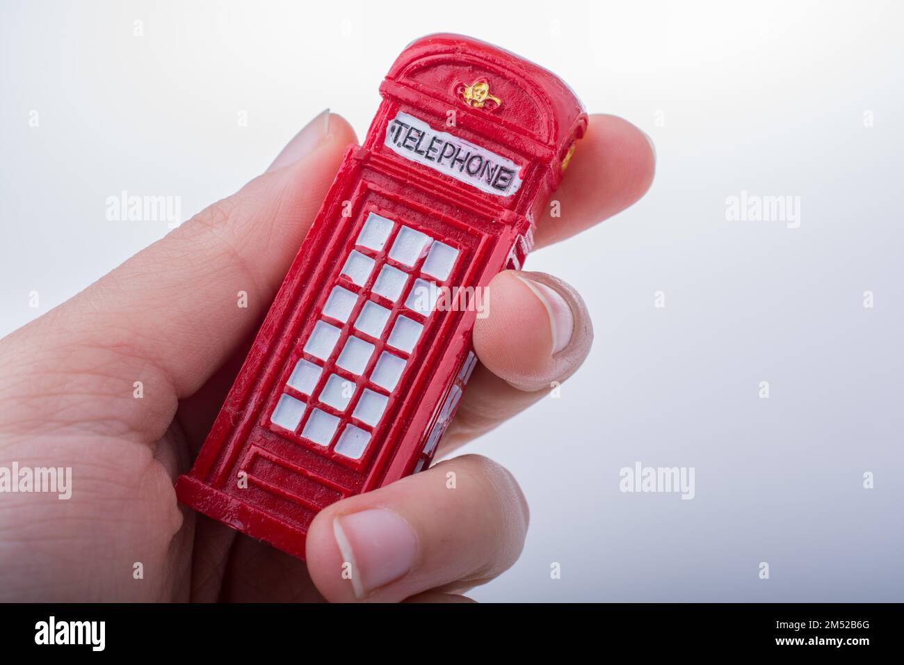 Hand holding a red color phone booth on a white background Stock Photo ...