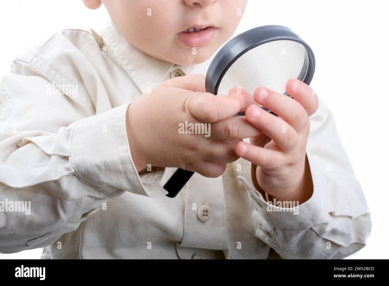 Baby holding a magnifying glass in hand on a white background Stock ...