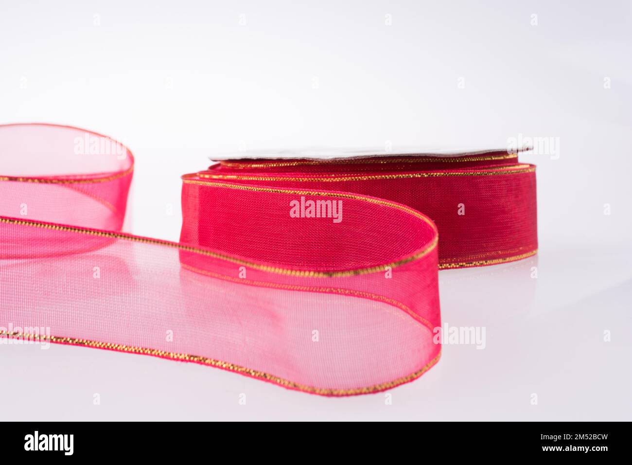 A roll of red ribbon, isolated on white Stock Photo - Alamy