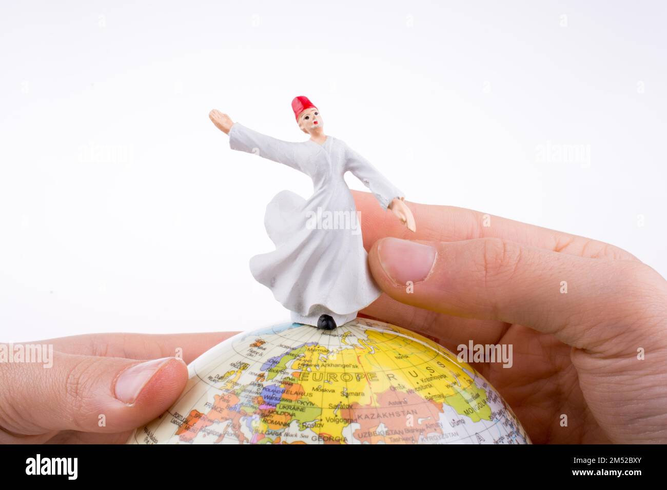 Hand holding a Sufi Dervis on a globe Stock Photo - Alamy