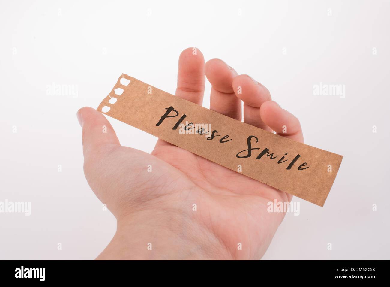 Please smile text on paper on a white background Stock Photo - Alamy
