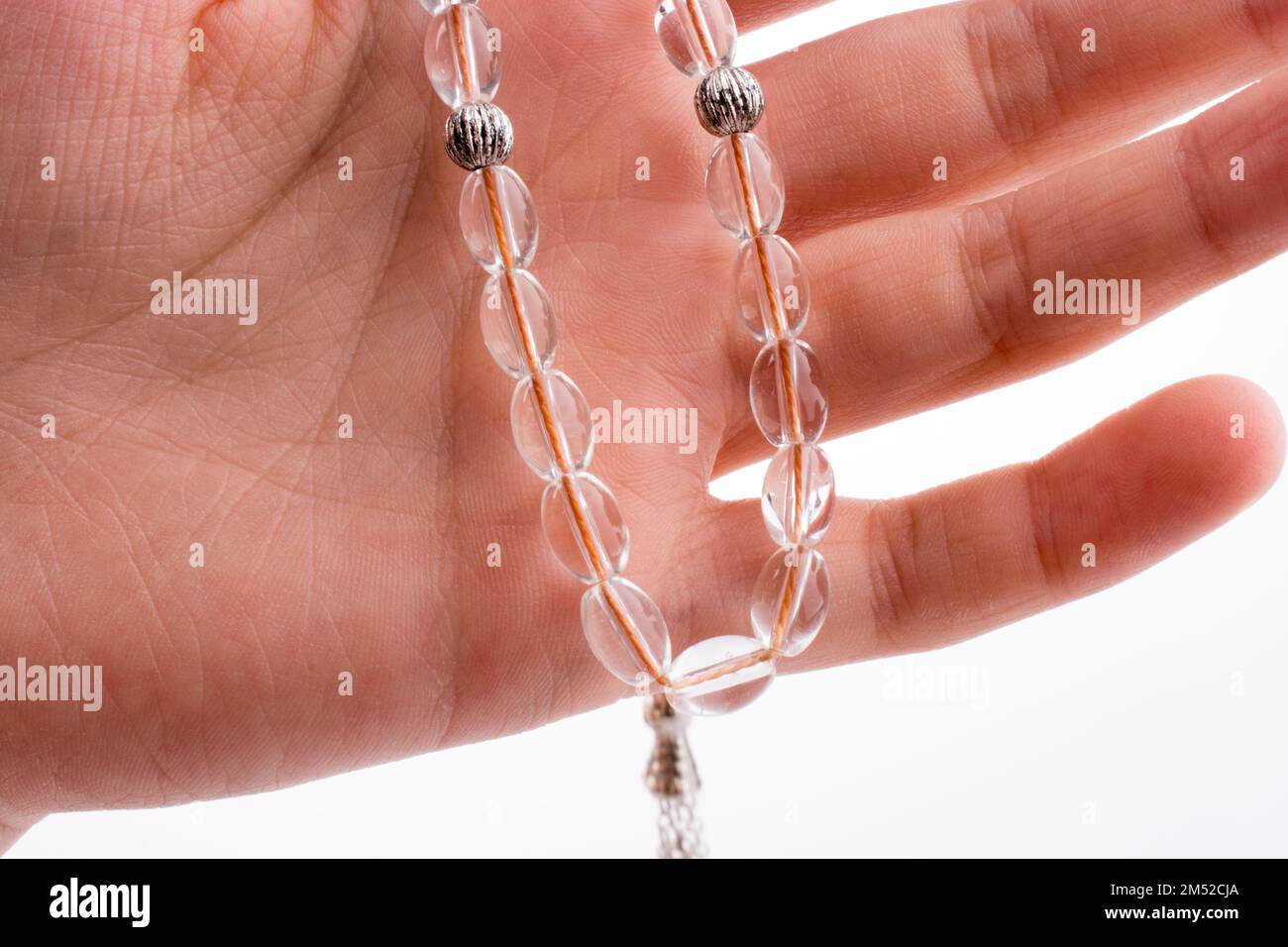 Hand holding a tespih on a white background Stock Photo - Alamy