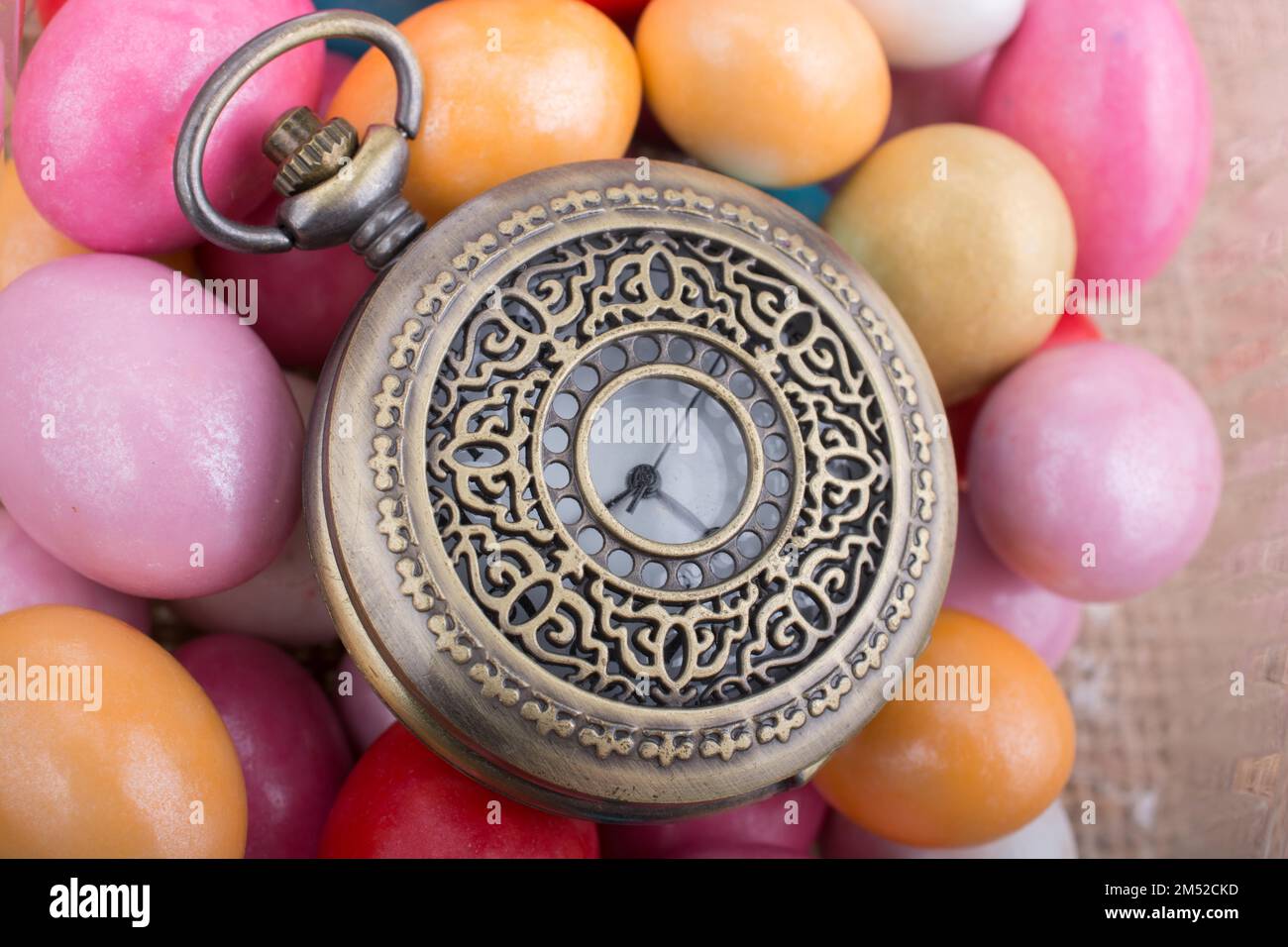 Mechanical pocket watch on colorful candy sweets Stock Photo - Alamy