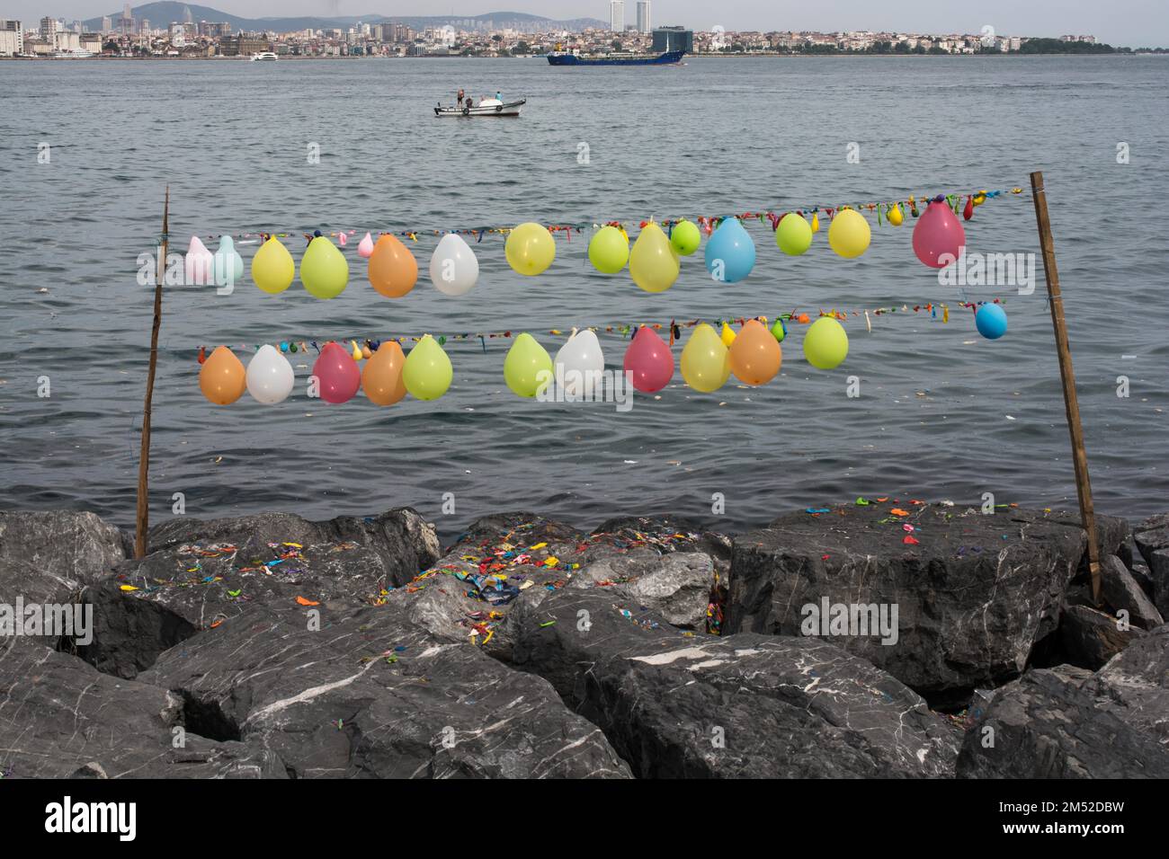 Balloon shooting game with balloons tied on a string Stock Photo - Alamy